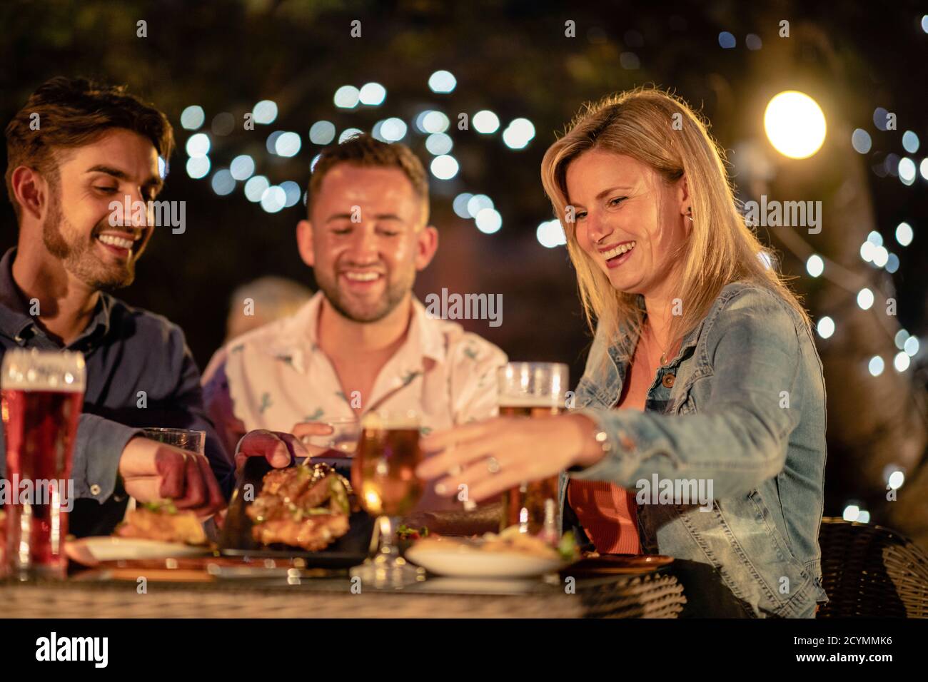 Group of friends drinking alcoholic drinks outdoors at a bar/restaurant ...