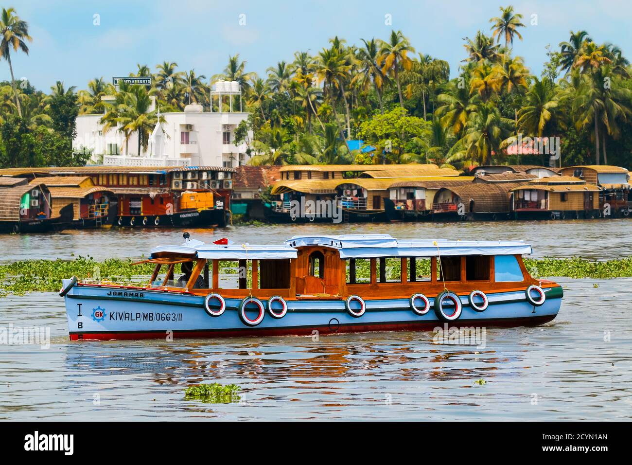 Colourful tour boat and moored houseboats for popular backwater cruises ...