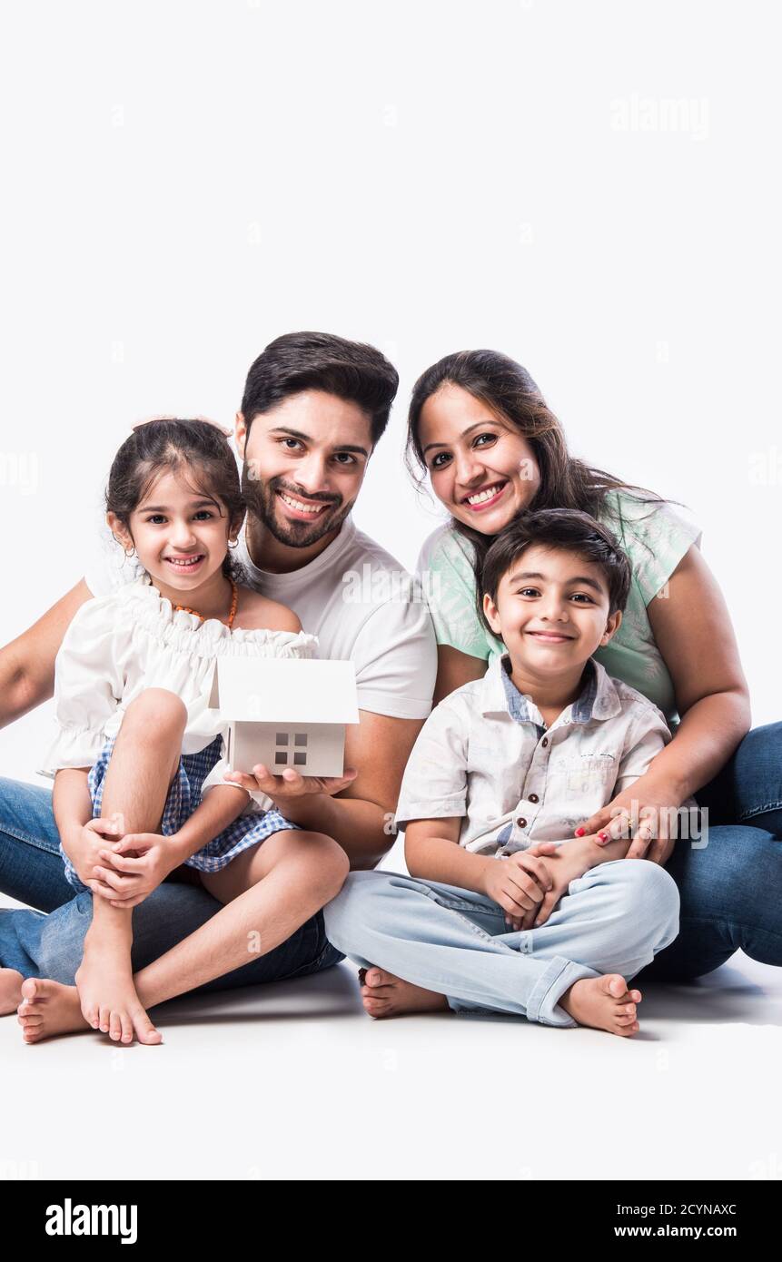 Indian family Father, mother, son and daughter holding 3D paper model ...