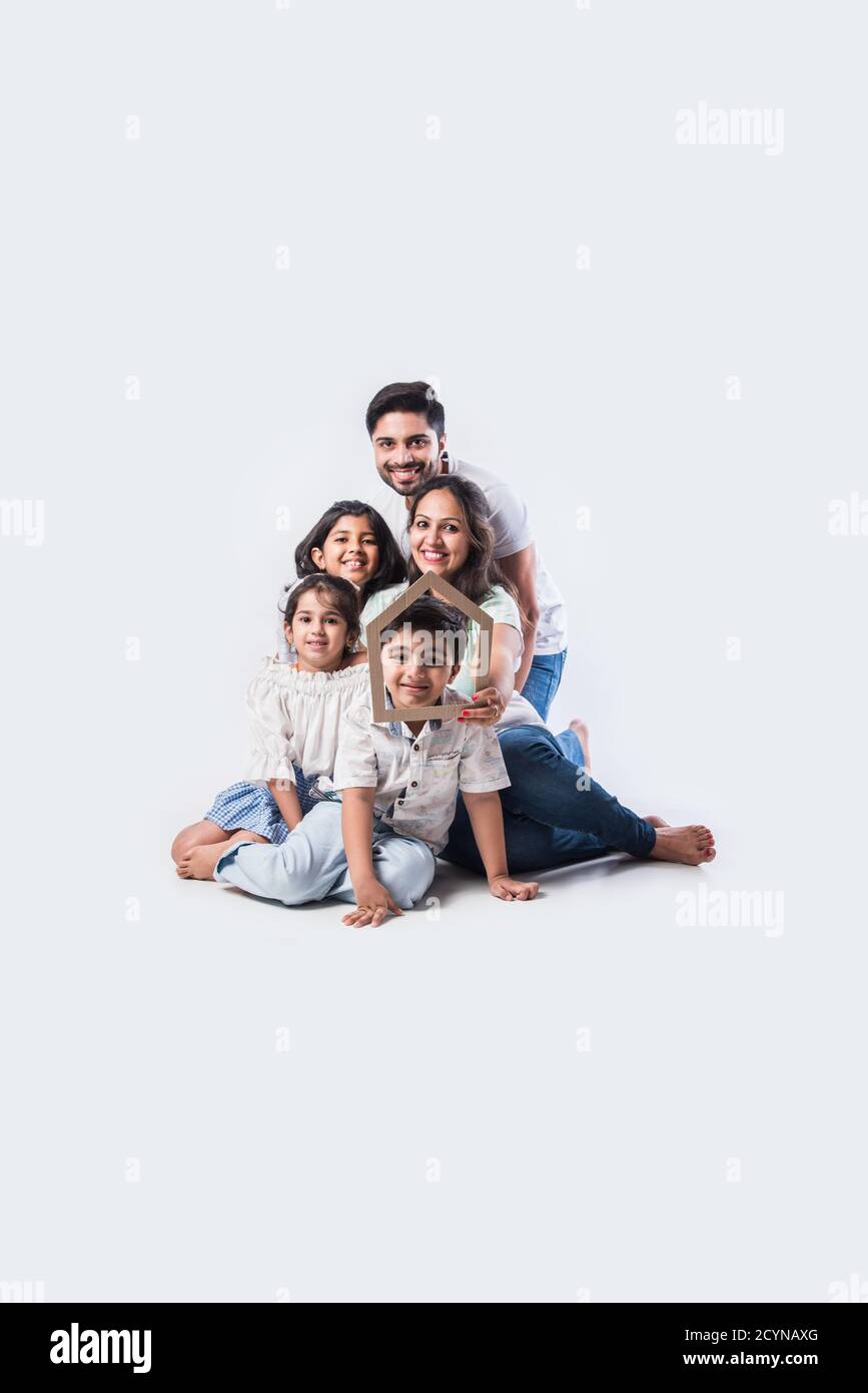 Indian family Father, mother, son and daughter holding 3D paper model ...
