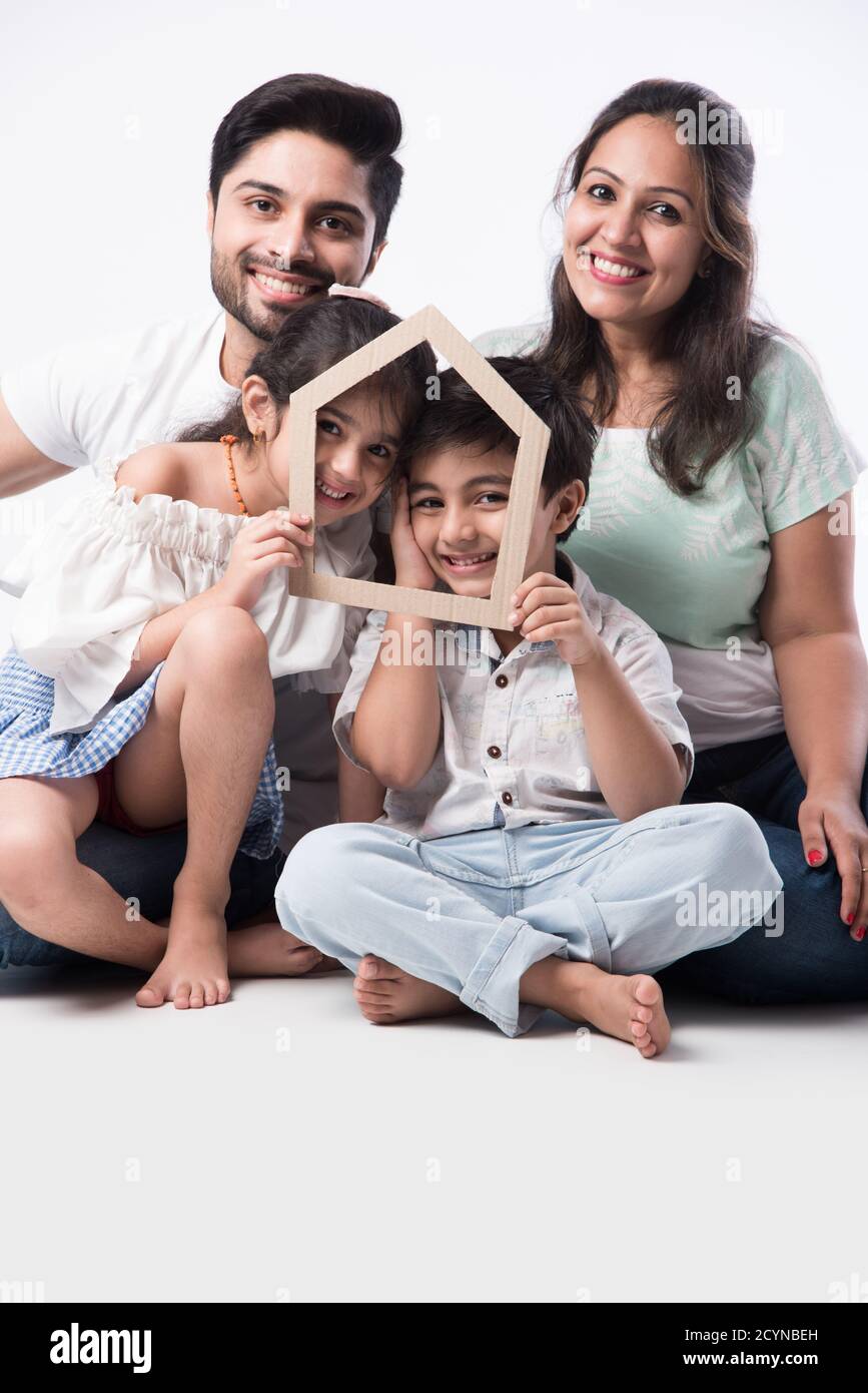 Indian family Father, mother, son and daughter holding 3D paper model ...