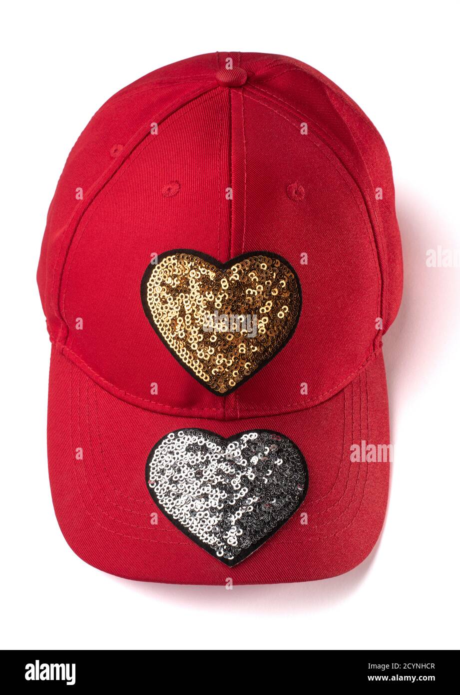 Red cap with golden and silver sequin heart patches on white background ...