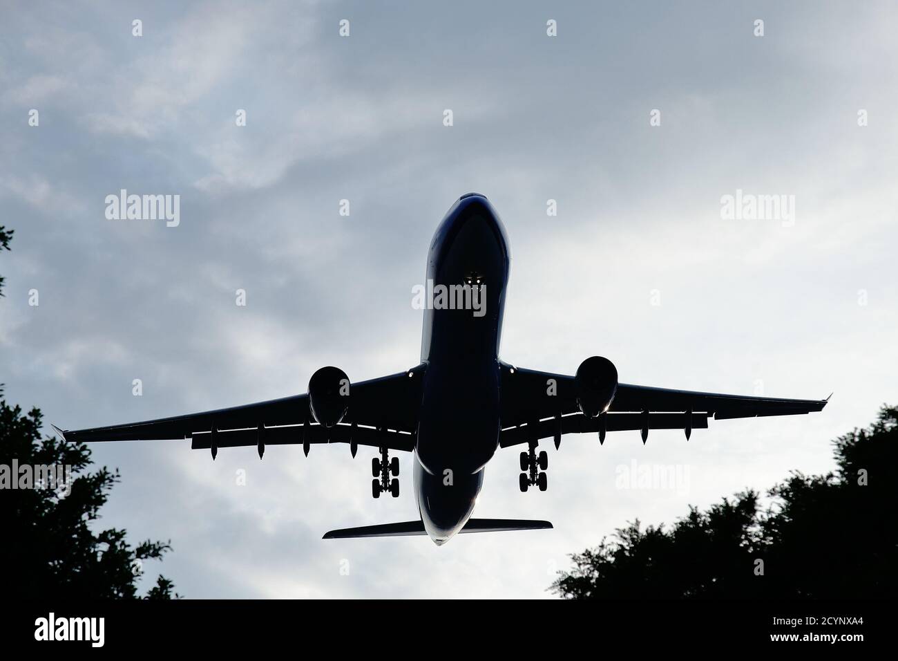 an airplane is flying low before landing Stock Photo - Alamy