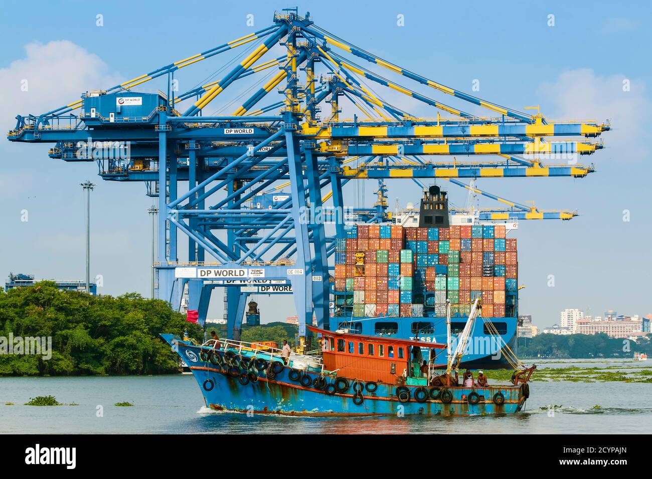 Fishing boat off Fort Cochin passing container ship & cranes at ...