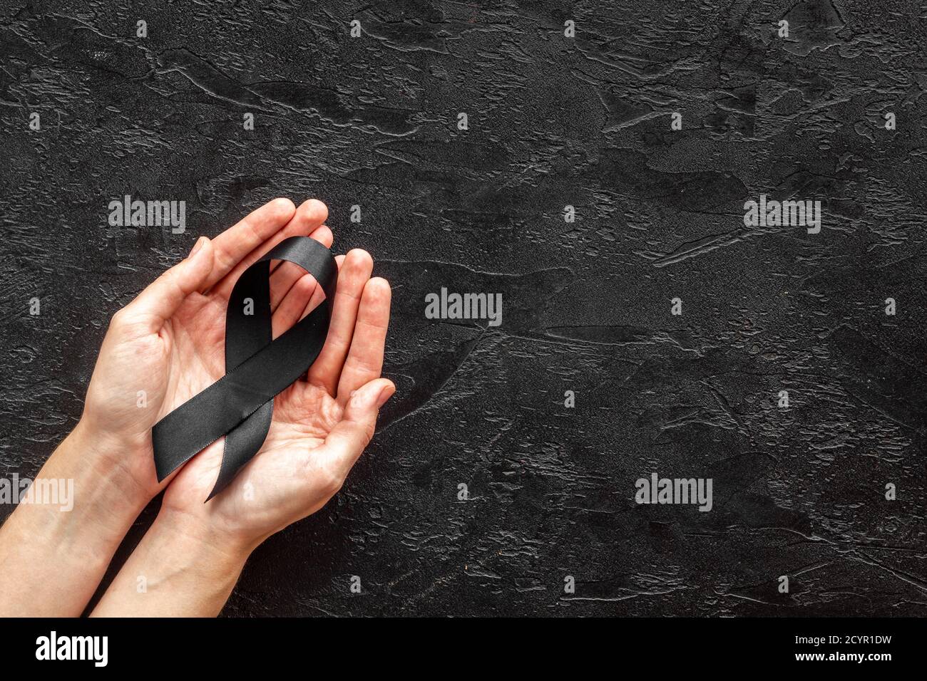 Hands holding black ribbon, top view. Funeral symbol Stock Photo - Alamy