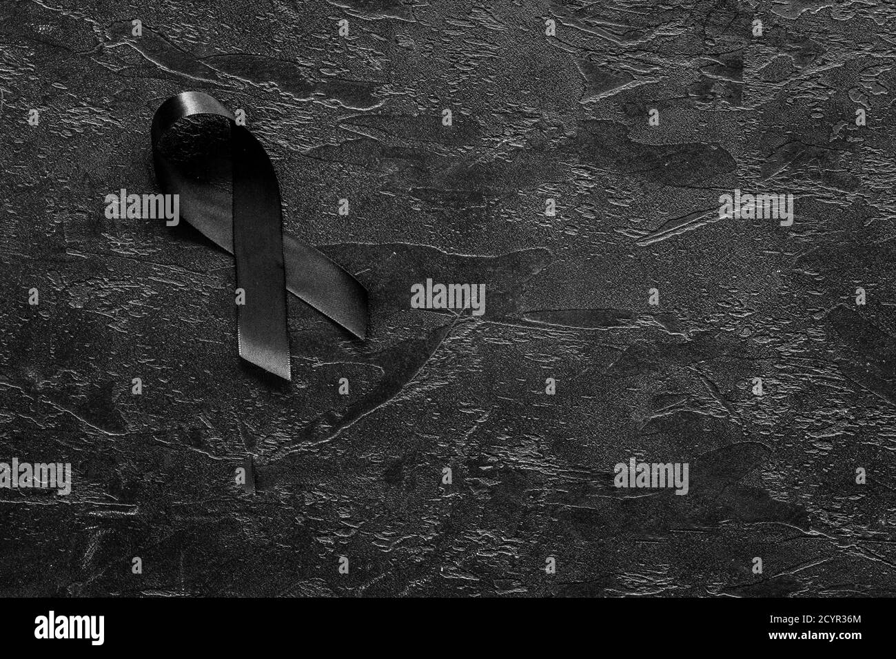 Black awareness ribbon on dark background. Mourning symbol Stock Photo ...