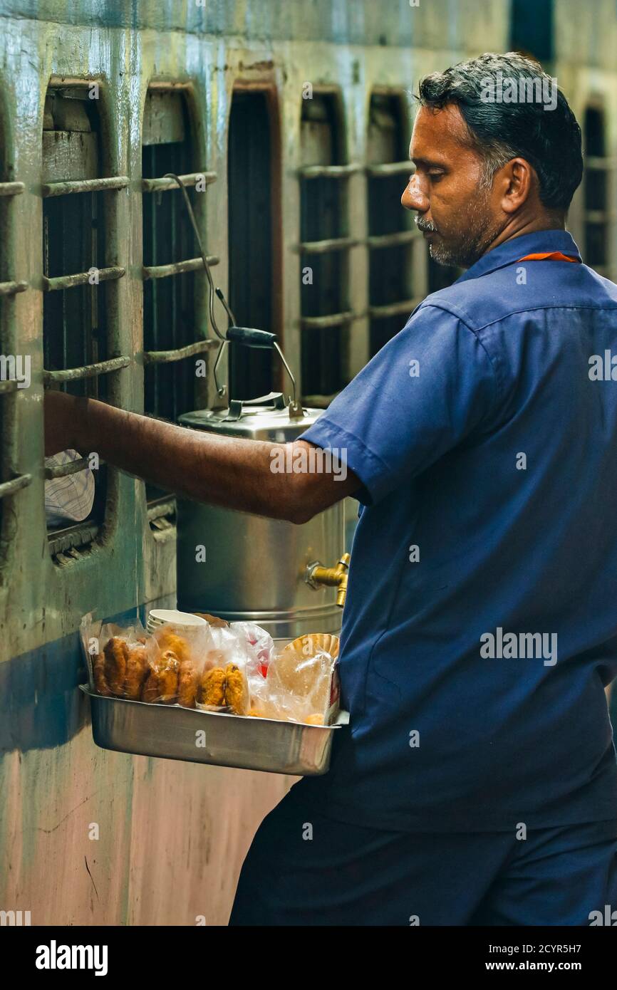Vendor sells somosas, fritters, fried snacks to train passengers at ...