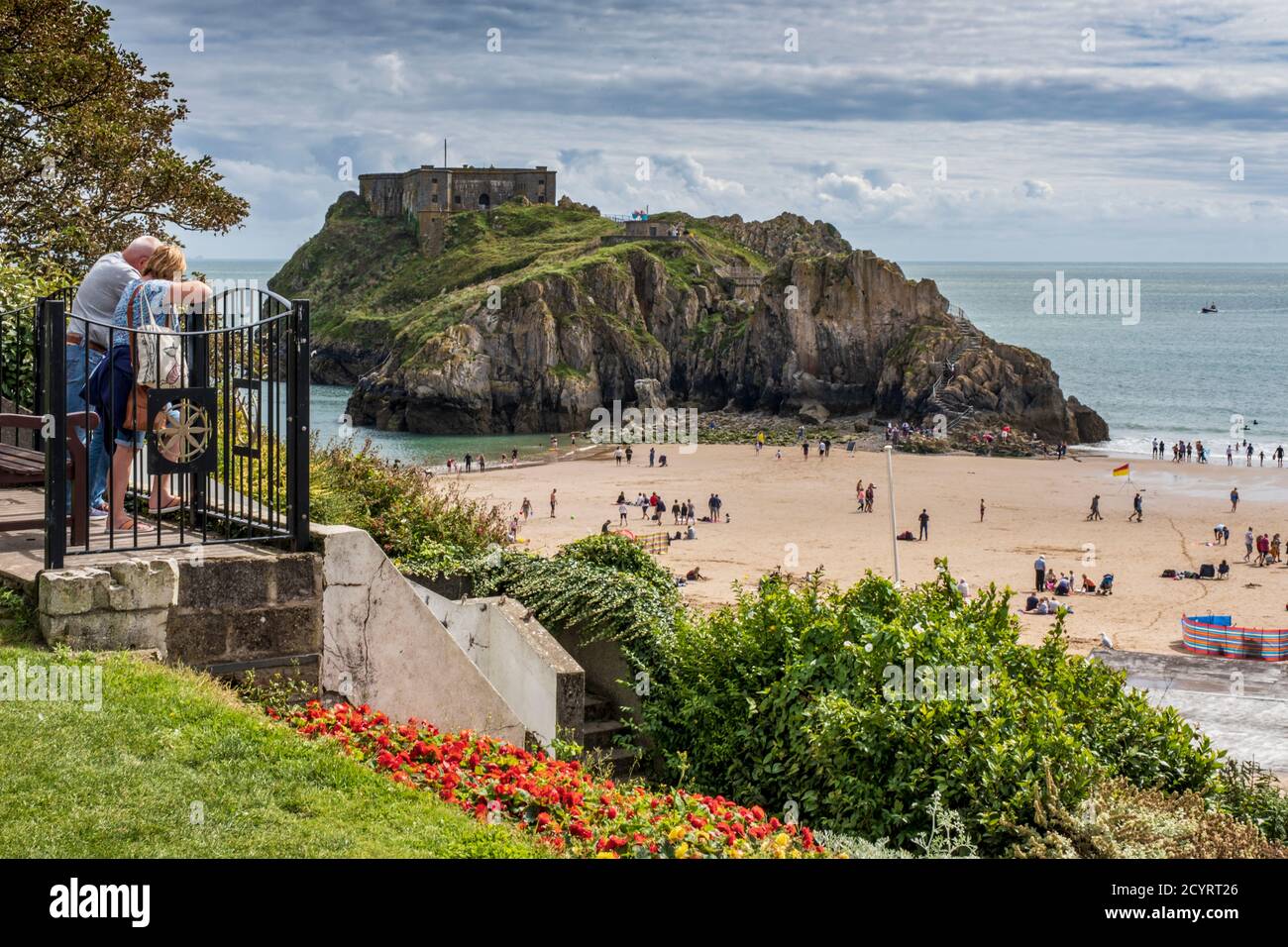 Two tourists enjoying the view of Tenby South Beach and St Catherine's ...