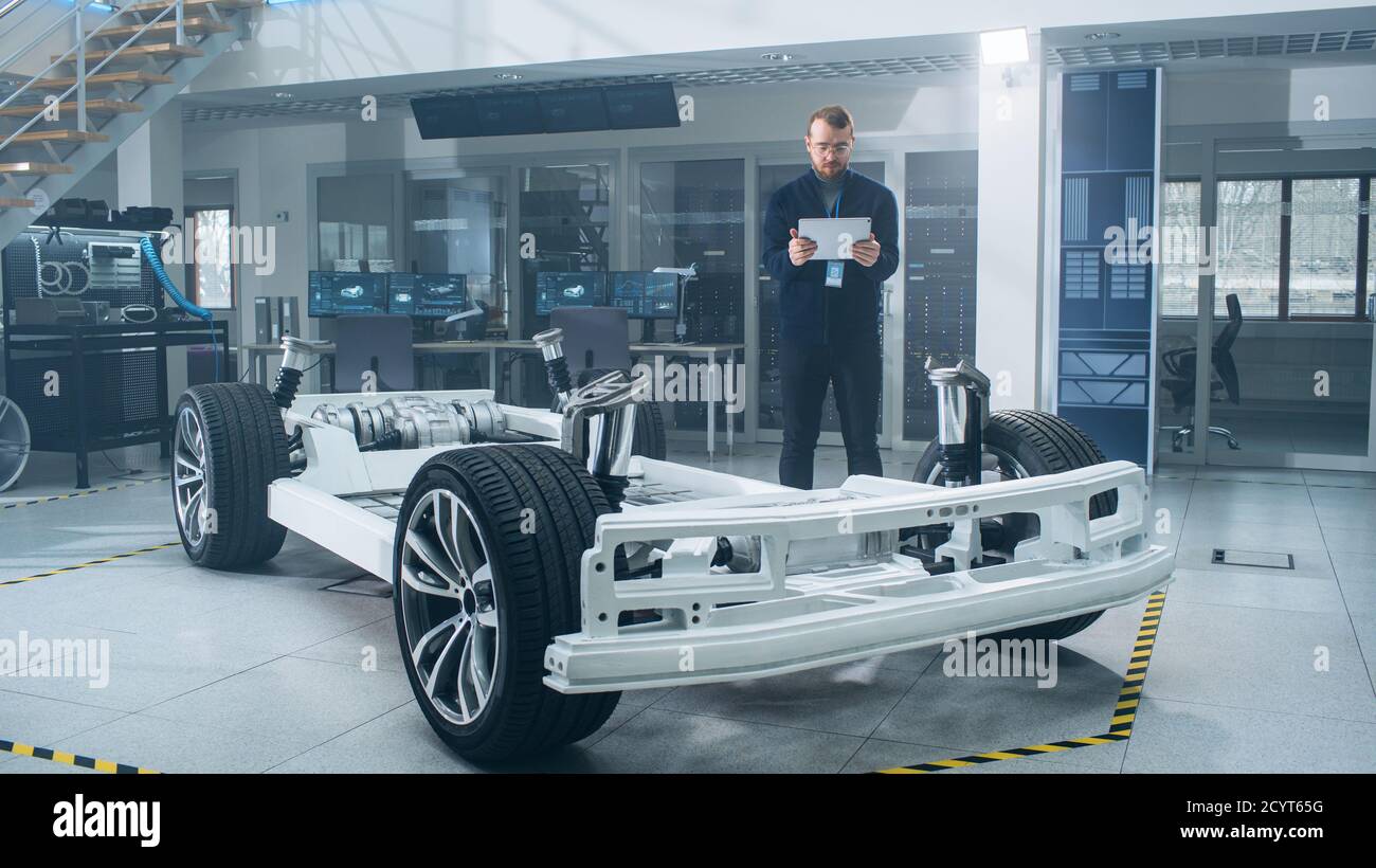 Engineer with Glasses and Beard Scans Electric Car Chassis Prototype ...
