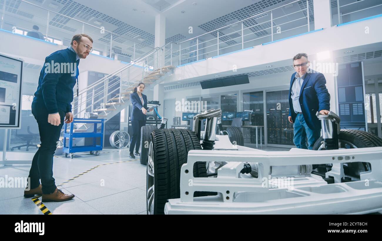 Automotive Design Engineers Talking while Working on Electric Car ...