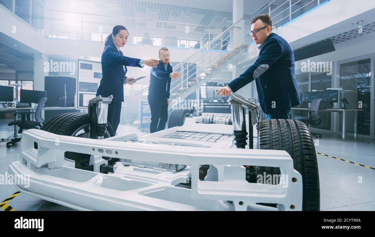 Automotive Design Engineers Talking while Working on Electric Car ...