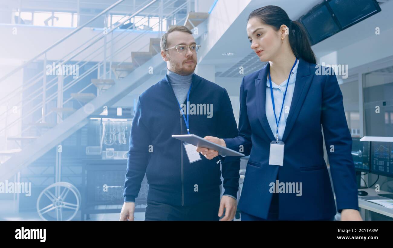 Female and Male Engineer in a High Tech Development Facility Holding a ...