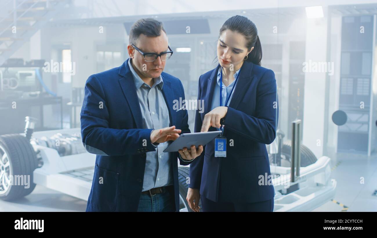 Female and Male Engineer Work in a High Tech Development Facility ...
