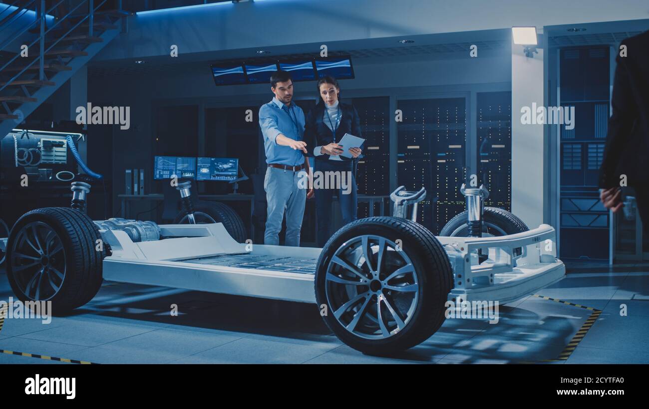 Auto Industry Design Facility: Male Chief Engineer Shows Car Prototype ...