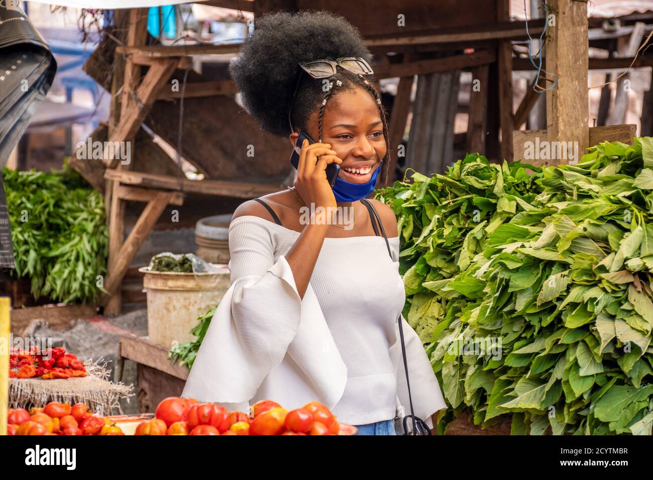 young african lady smiling while making phone call in a market Stock ...