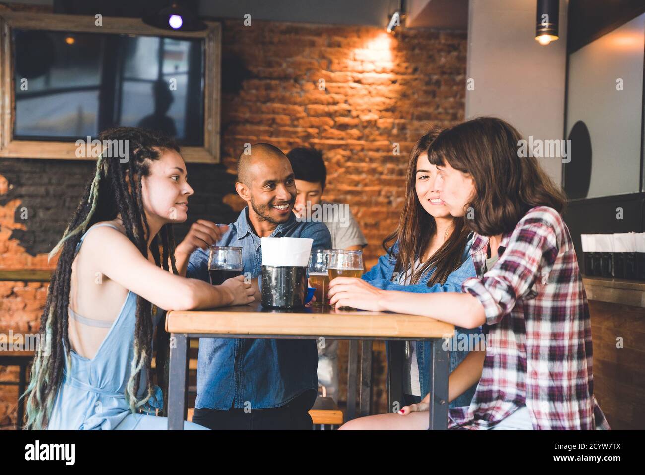 A group of international friends having beers together in a restaurant ...