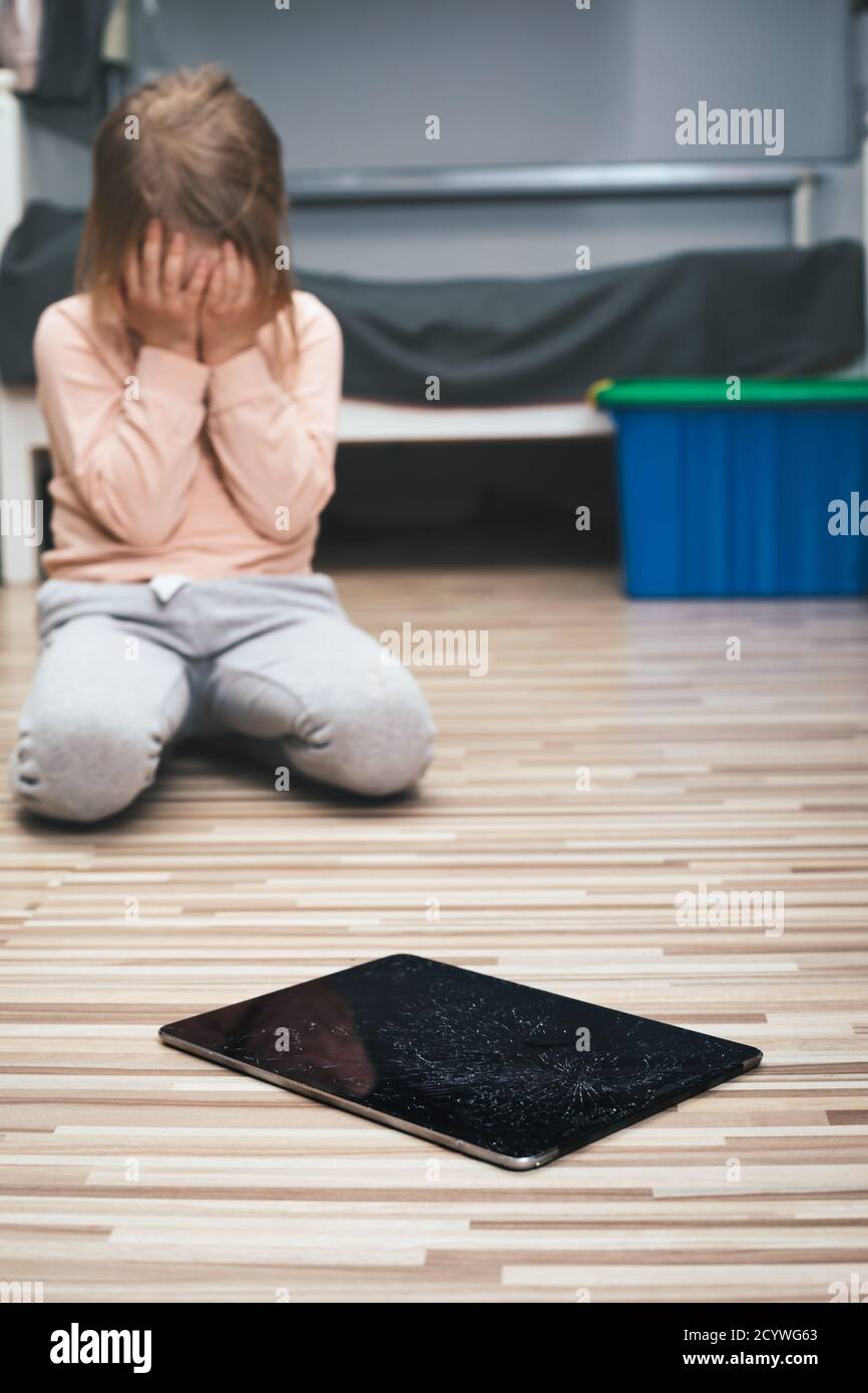 Little gird accidentally broke a tablet computer. Focus on cracked ...