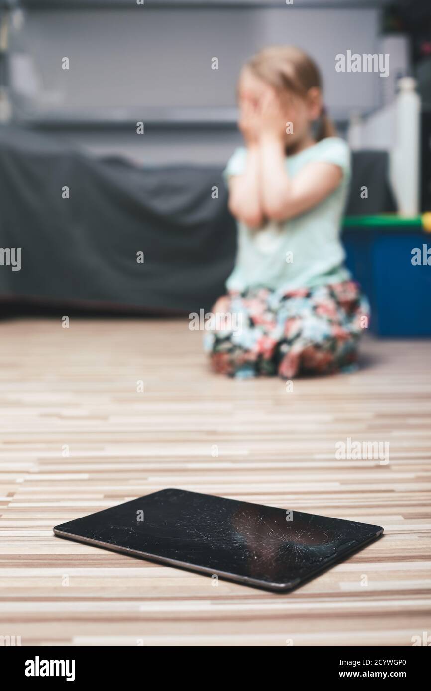 Little gird accidentally broke a tablet computer. Focus on cracked ...