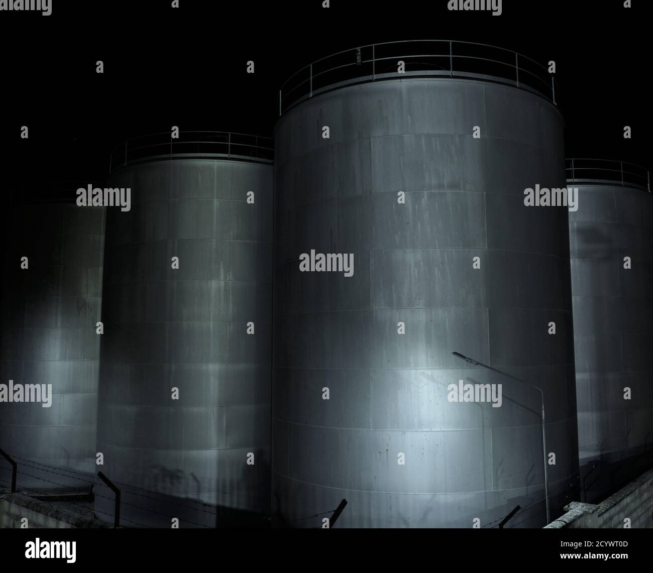 Metallic storage tanks at night in an industrial facility Stock Photo ...
