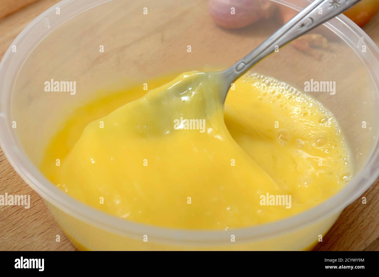 mixing yolk and white eggs, in a plastic bowl using fork. preparation ...