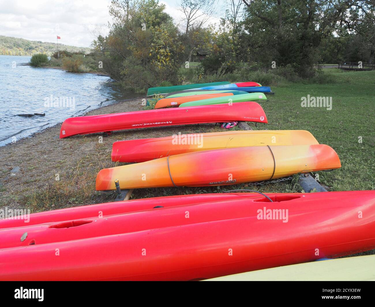 The colorful canoes are lined up on the shoreline Stock Photo - Alamy