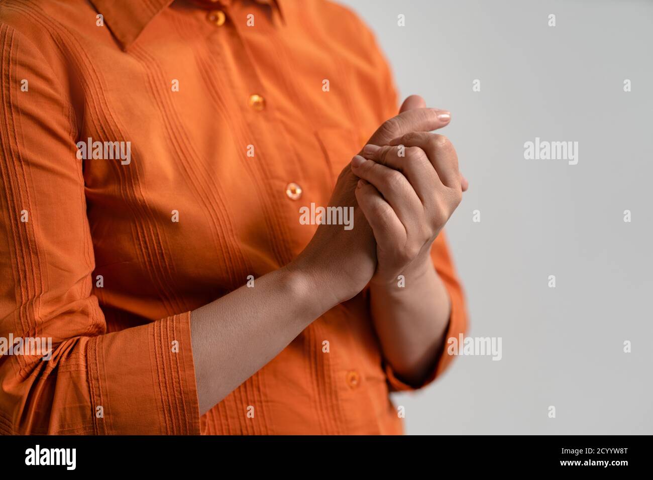 Female hands are folded into a lock. Close up shot. Woman wearing ...