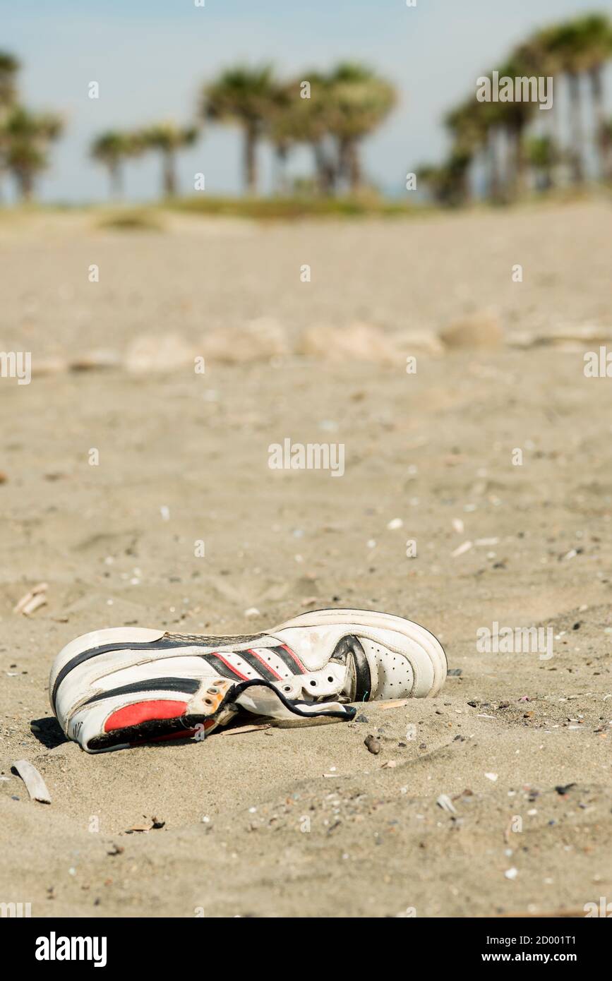 Snickers shoe abandoned on sand beach, plastic pollution Stock Photo ...