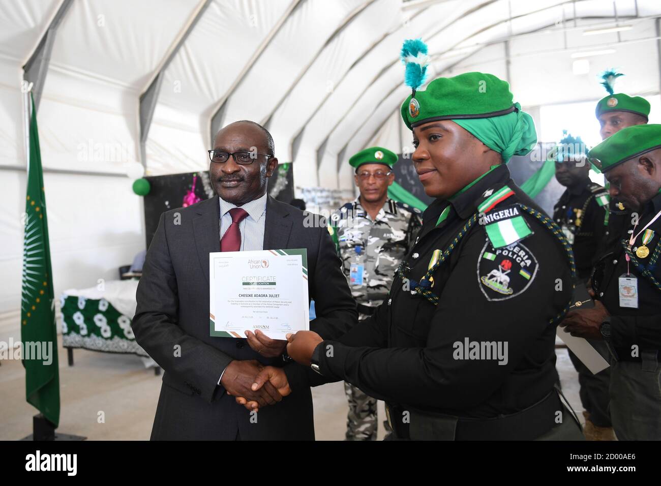 Simon Mulongo, Deputy Head of AMISOM, presents a certificate to a ...