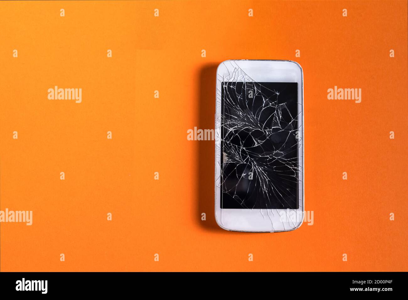 Broken mobile phone with cracked display on orange background, outdoor ...