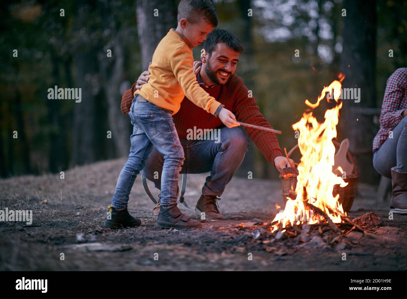 Father and son starting a fire together on a camping; Quality family ...