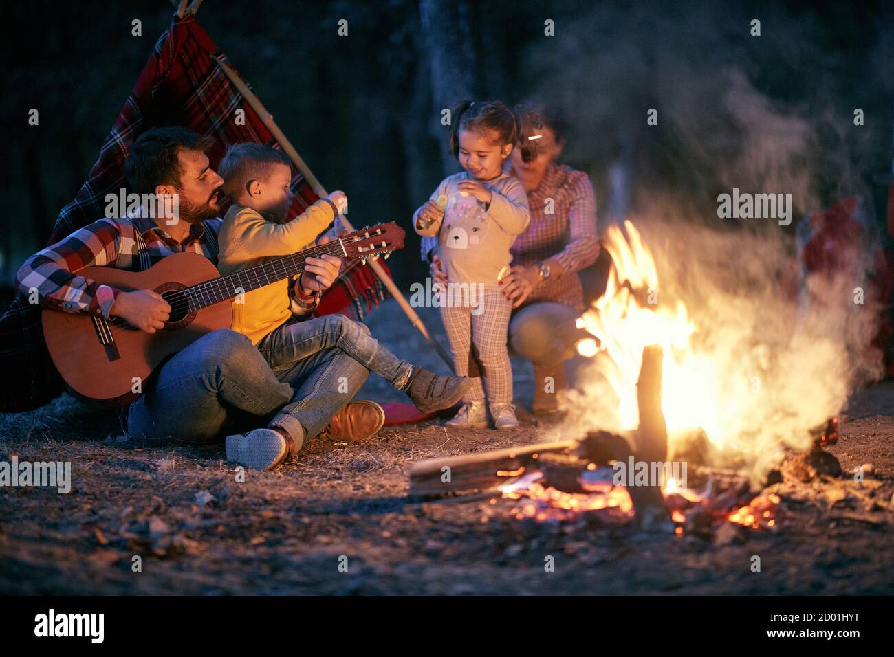 Family camping in the woods with guitar; Spring or autumn camping with ...