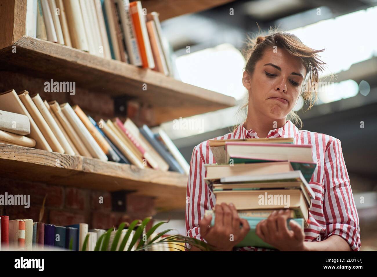 A young girl picked bunch of books at a cafes library Stock Photo - Alamy