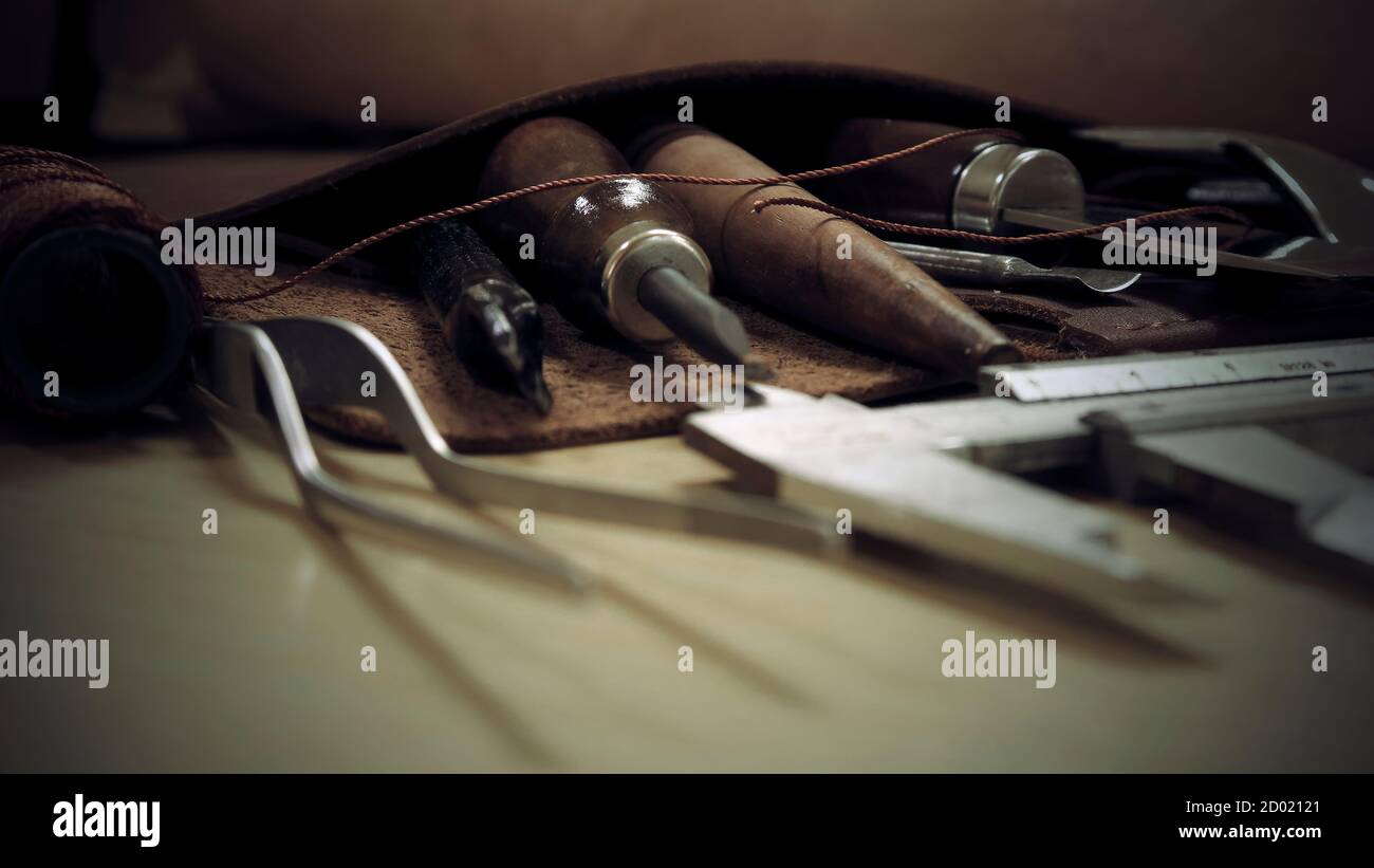 Leather craft tools on a wooden table at traditional workshop Stock ...