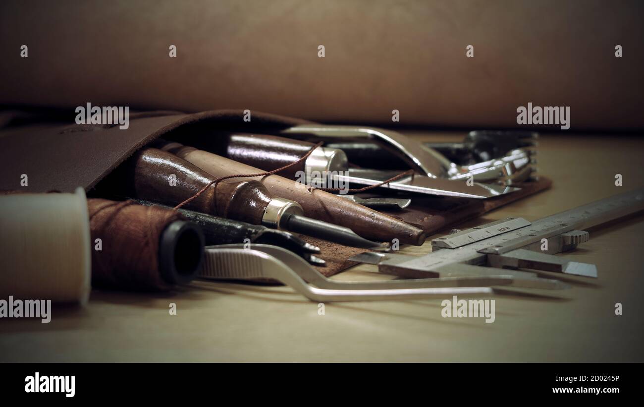 Leather craft tools on a wooden table at traditional workshop Stock ...