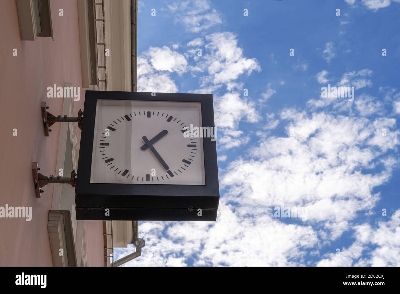 Modern street clock on the wall of a building Stock Photo - Alamy
