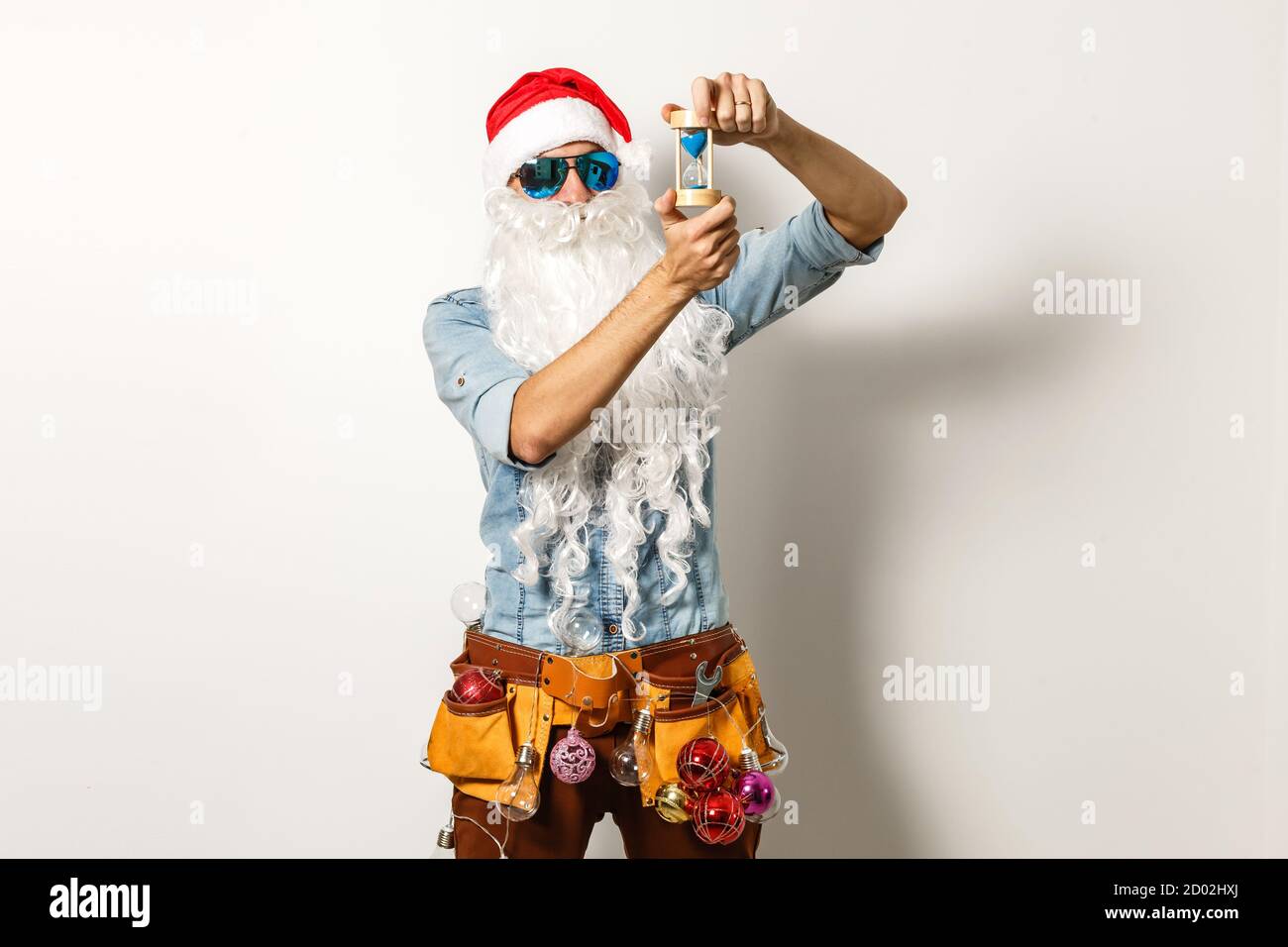 Santa on a white background pointing to an hour glass indicating that ...