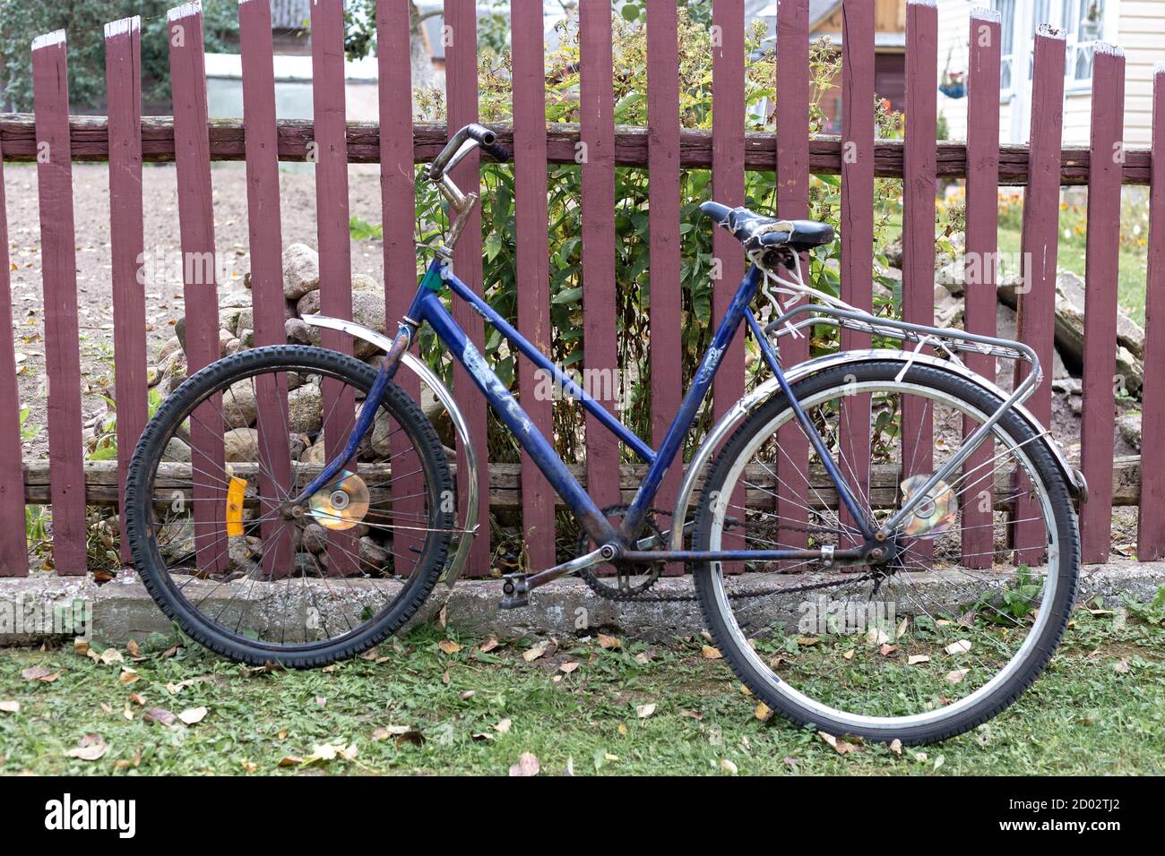 Old blue bike near brown wooden fence Stock Photo - Alamy