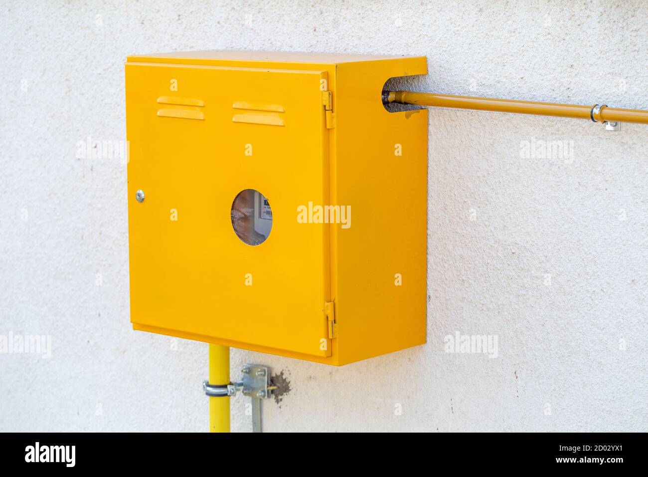 Domestic gas meter on wall outside mounted cabinet with yellow gas ...