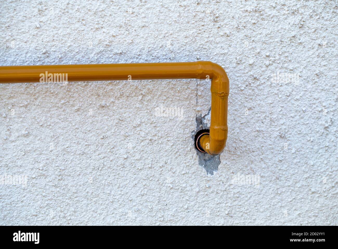 Domestic yellow gas pipe in front of house wall Stock Photo - Alamy