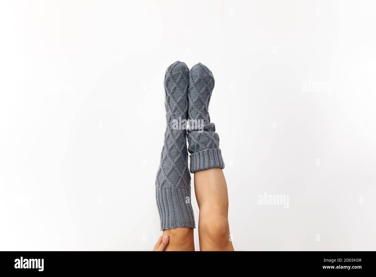 Gray knitted knee socks on the legs on a white background. Legs in long ...