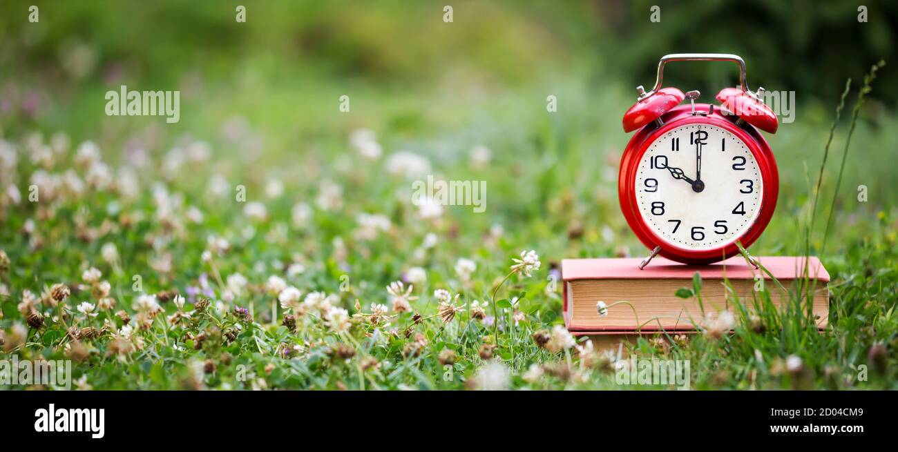 Save time, daylight savings concept, alarm clock on old books in the ...
