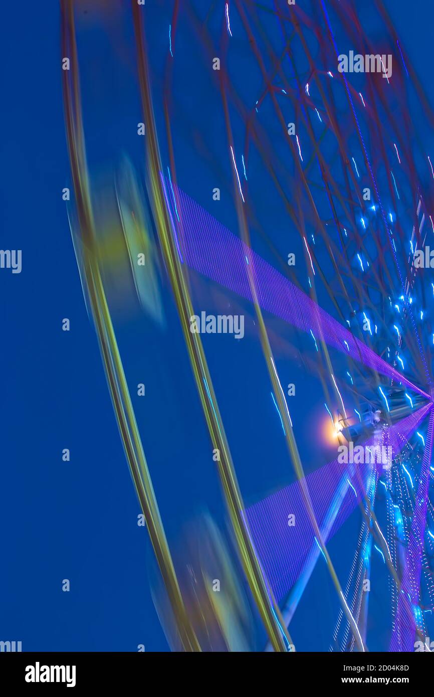 Carnival ride showing a spinning ferris wheel in action- long exposure ...