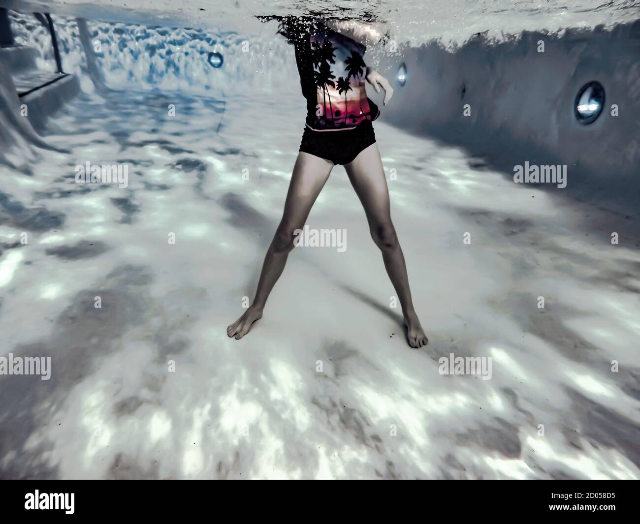 Teenage girl underwater running with light refracting off the sides of ...