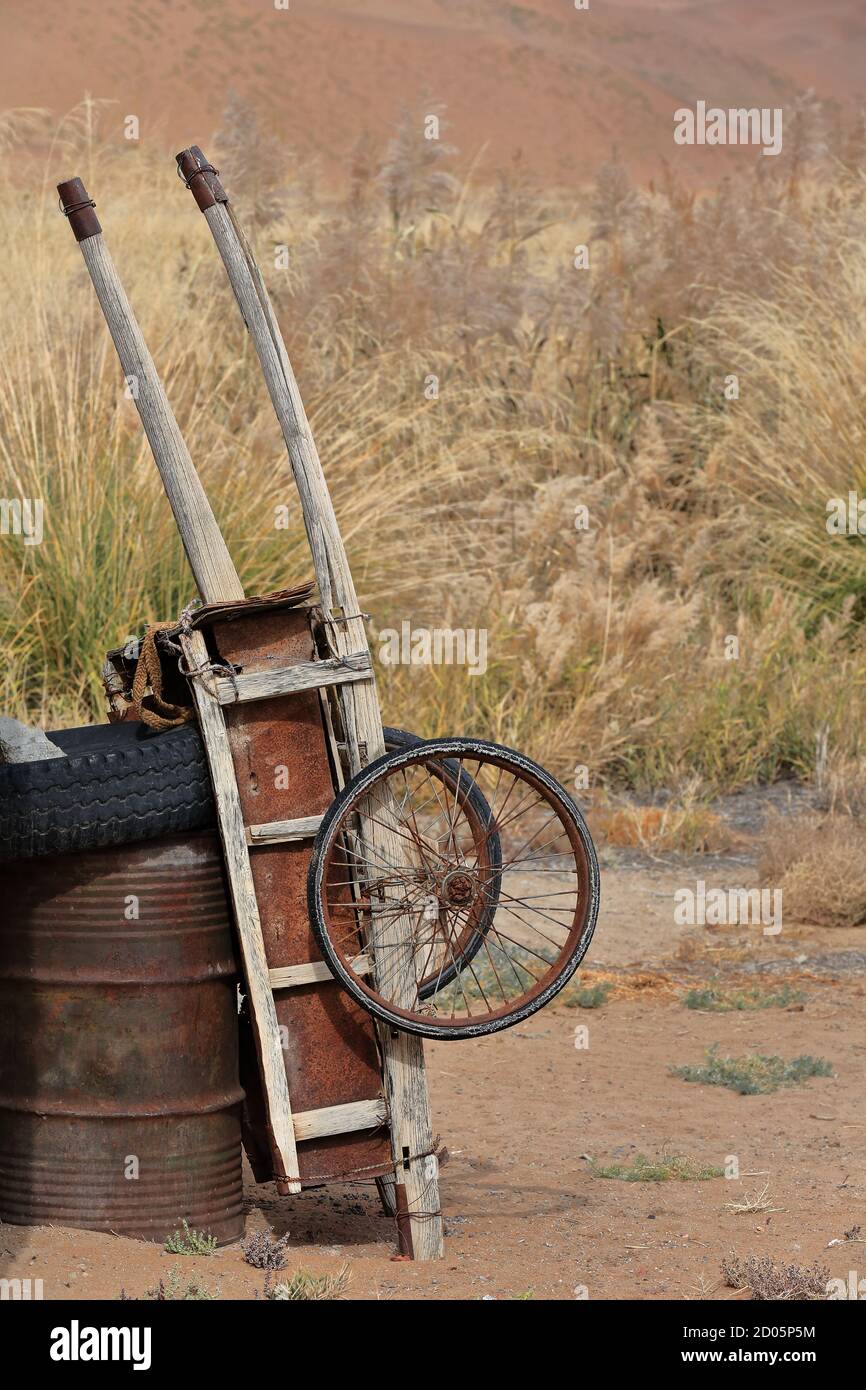 Rusty old cart leaning on oxidized oil drum-Badain Jaran Desert-China ...