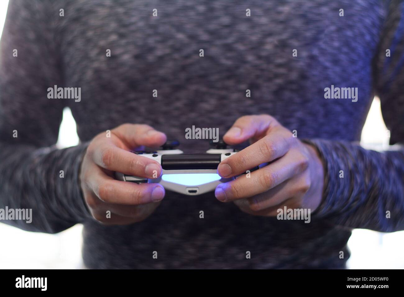 A man holding a game controller. A young man playing video games Stock ...