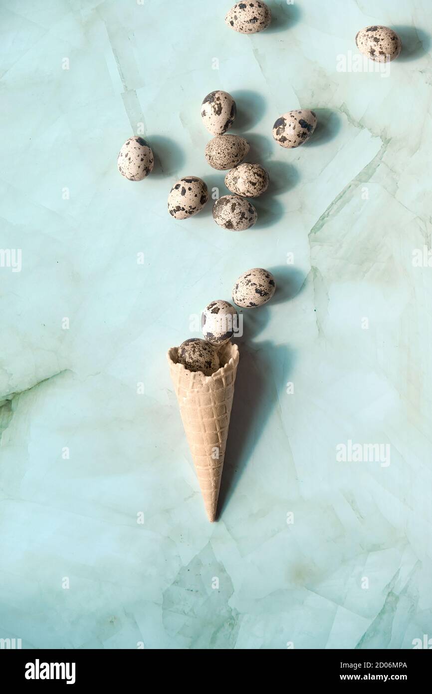 Easter flat lay with quail eggs flying out of waffle ice cream cone ...