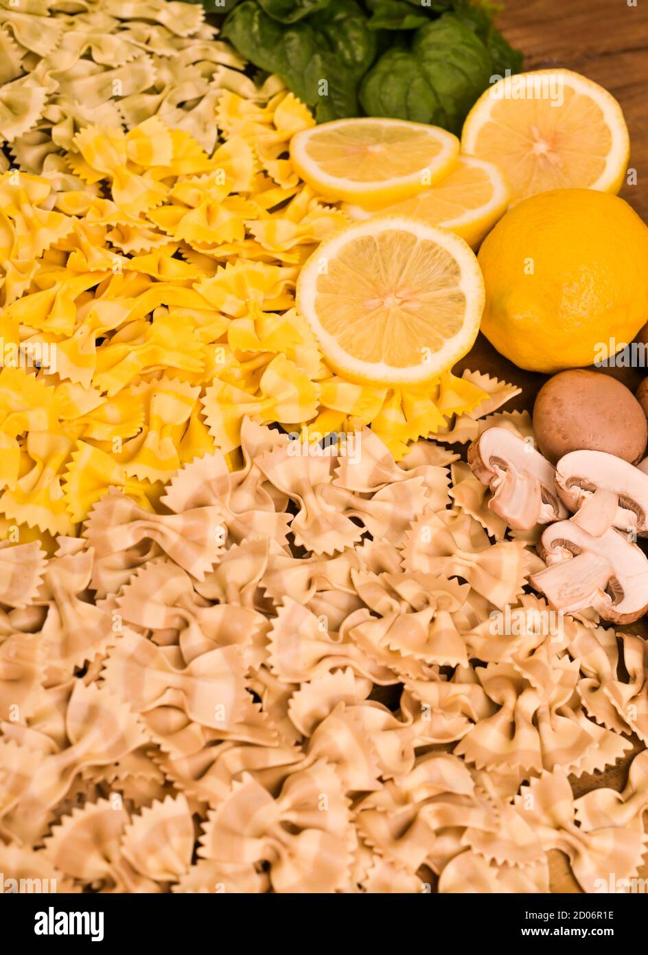 Dry Butterfly pasta with different flavors on a wooden background ...