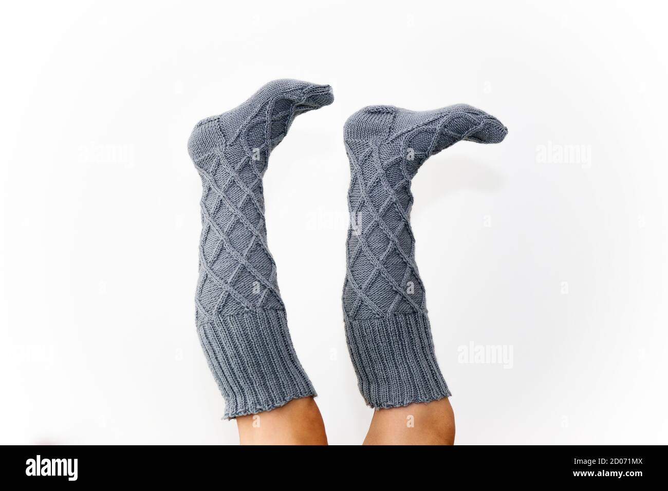 Gray knitted knee socks on the legs on a white background. Legs in long ...