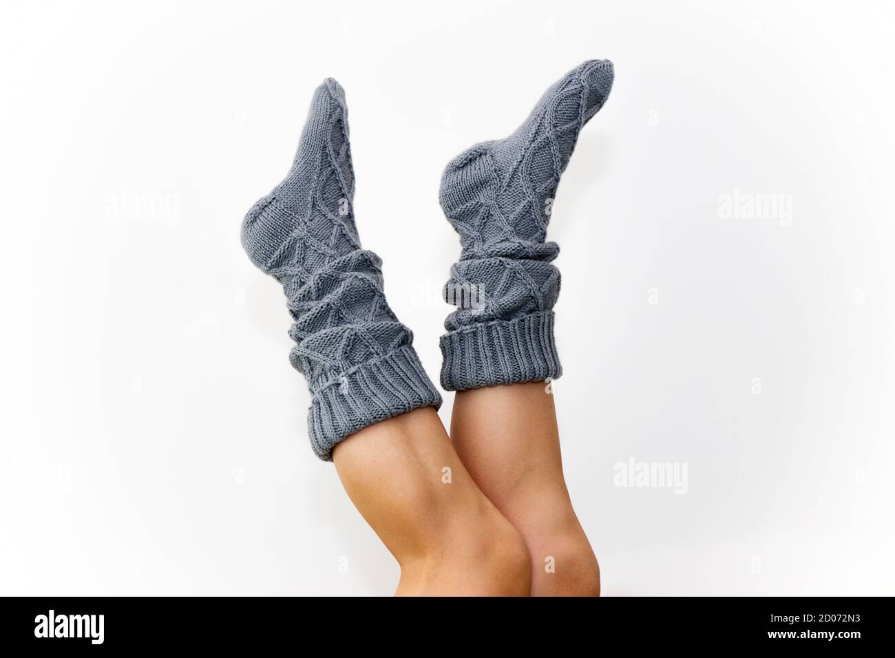 Gray knitted knee socks on the legs on a white background. Legs in long ...