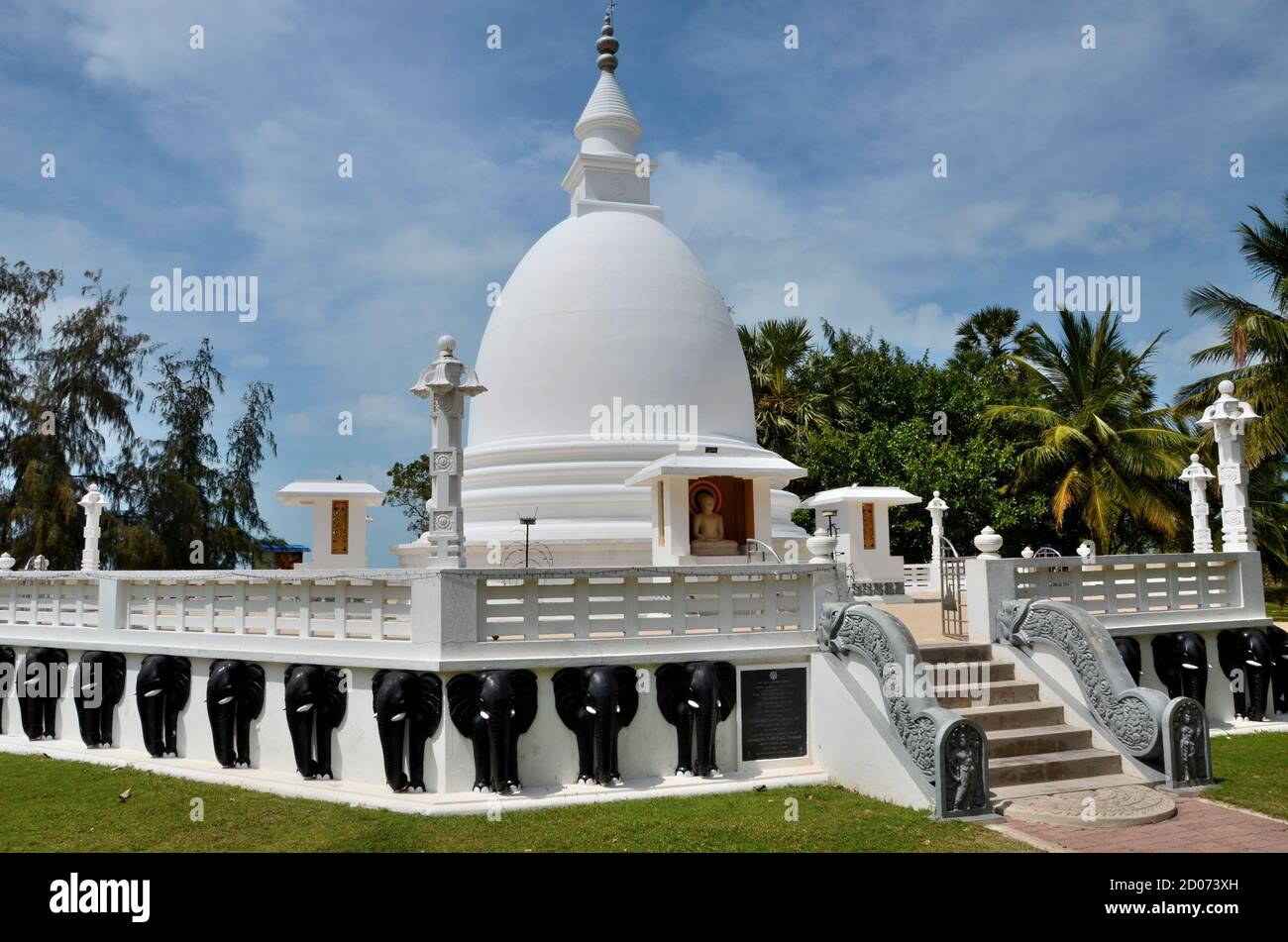 Buddhist stupa with Buddha statue at the Dambakola Patuna Sangamitta ...
